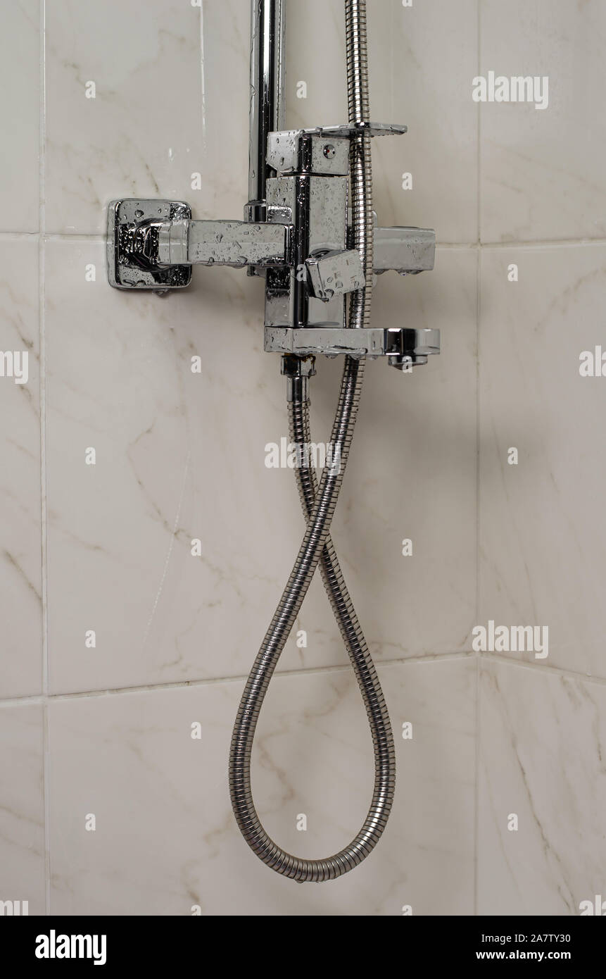 Wet water tap or faucet handing on the wall in shower stall. Copy space ...