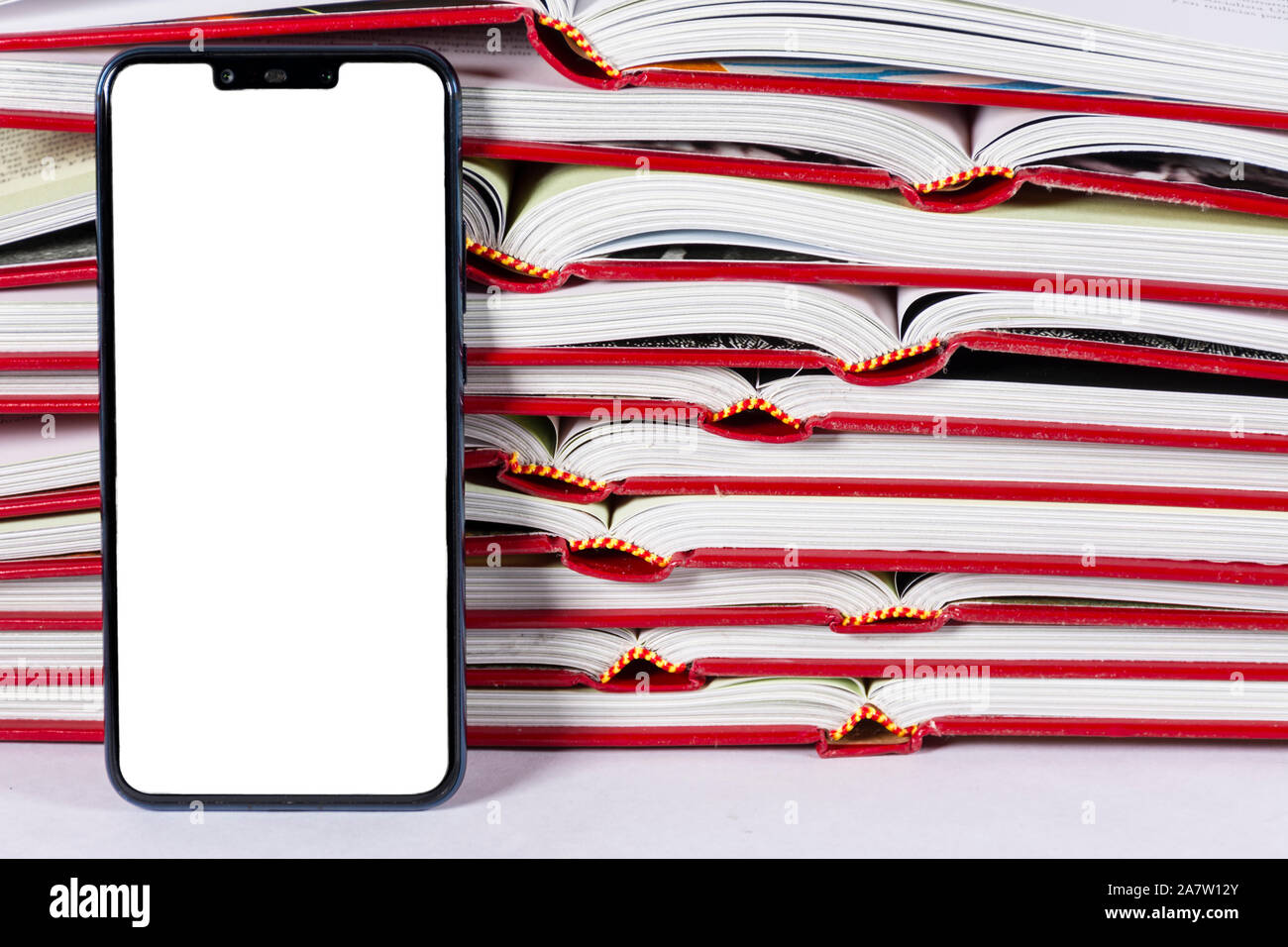 Pile of opened books with a smartphone with white screen Stock Photo ...