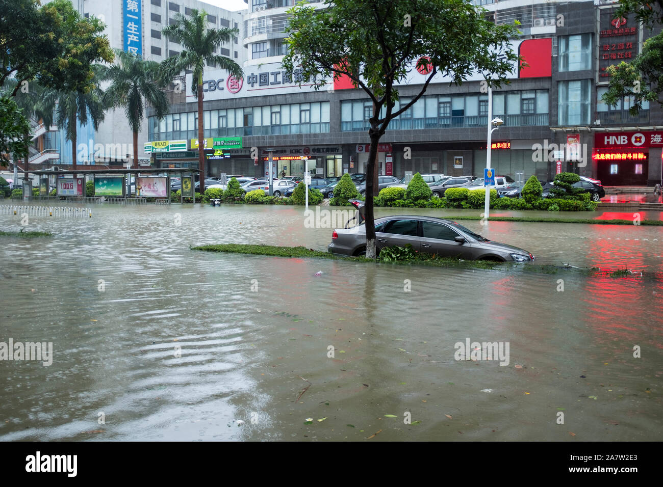 A car drives on a flooded road after a heavy rainstorm caused by ...