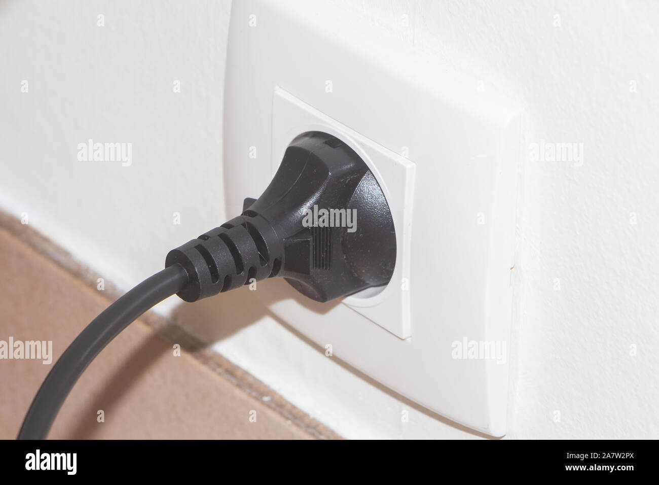 Plug in a socket in the wall of an house Stock Photo - Alamy