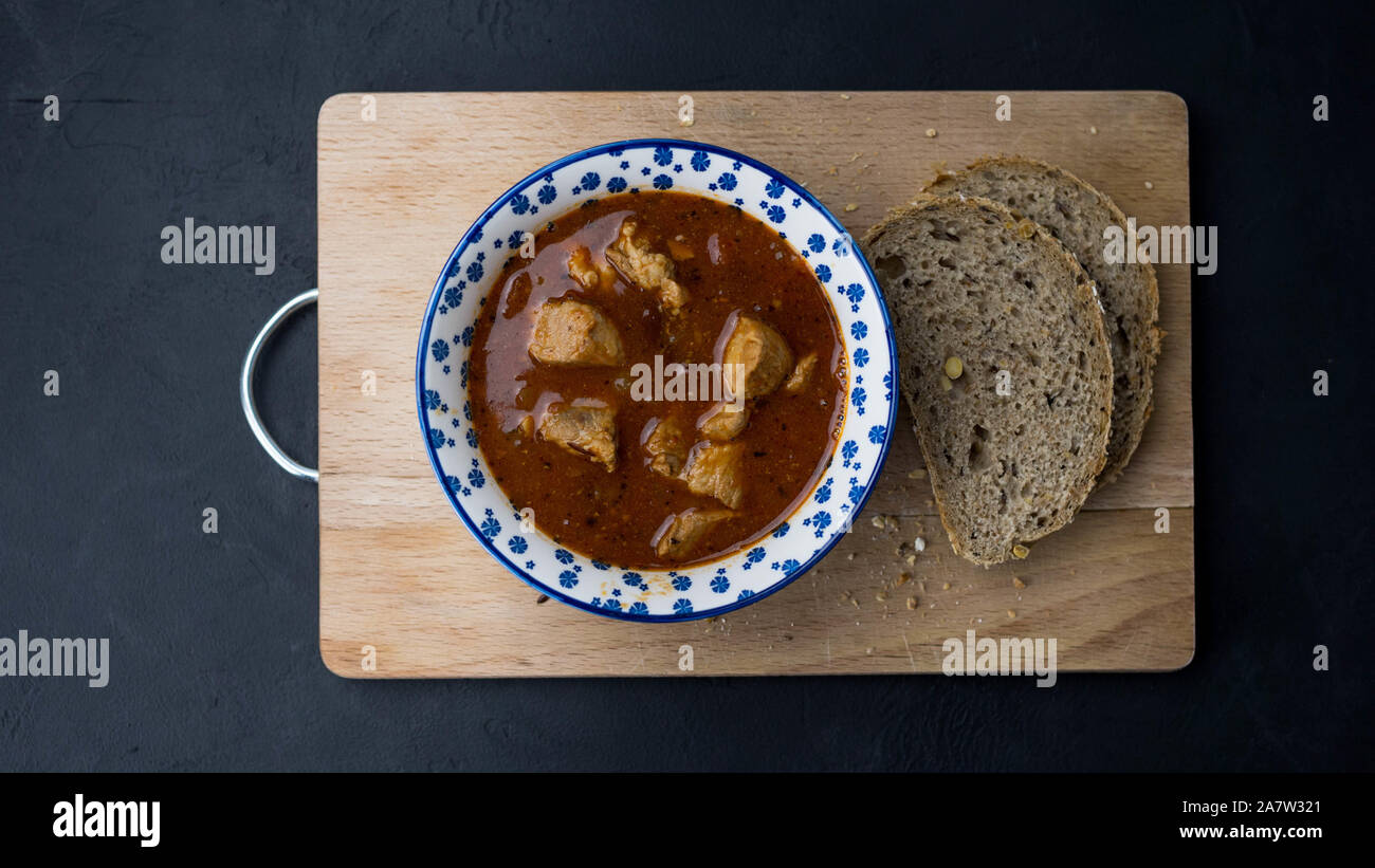 A warm soup with meat lying on a wooden chopping board. Polish delicacy ...