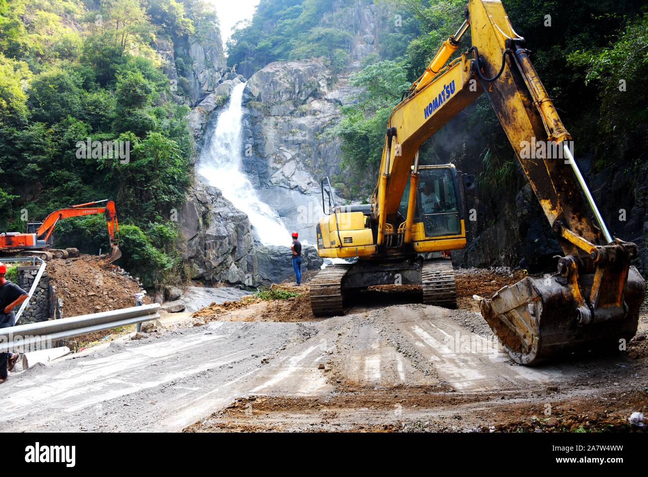 Chinese workers reconstruct a road devastated by floodwater after heavy ...