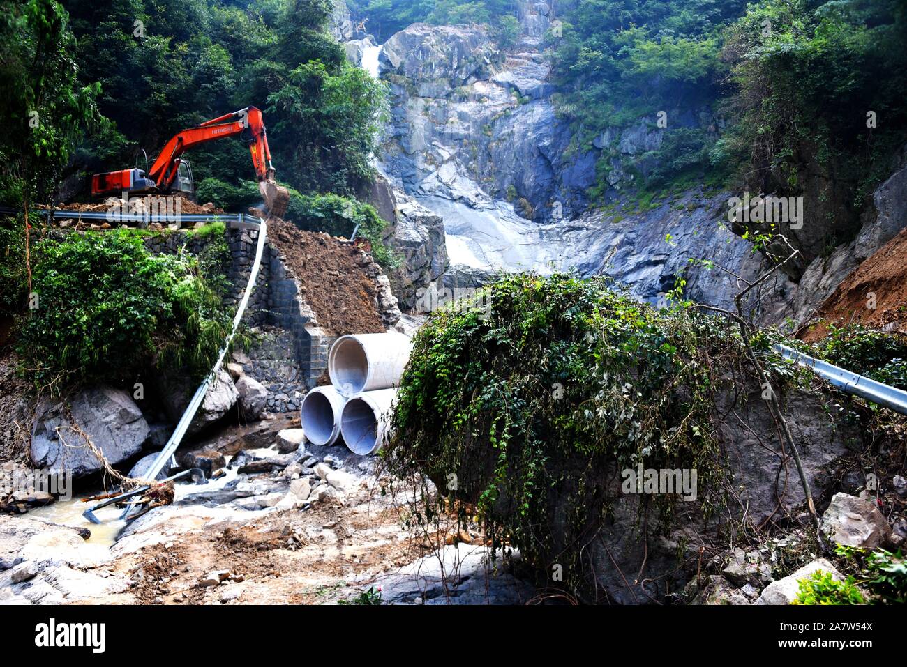 Chinese workers reconstruct a road devastated by floodwater after heavy rainstorm caused by the ...