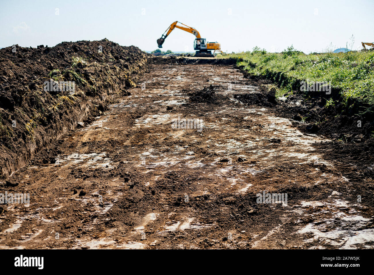 Excavator digging dirt in the field Stock Photo - Alamy