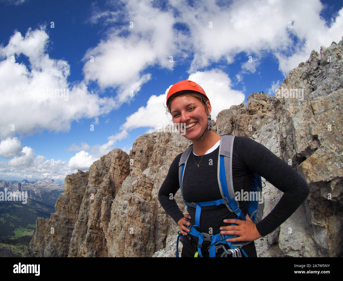 An attractive brunette female climber on a mountain peak in the ...