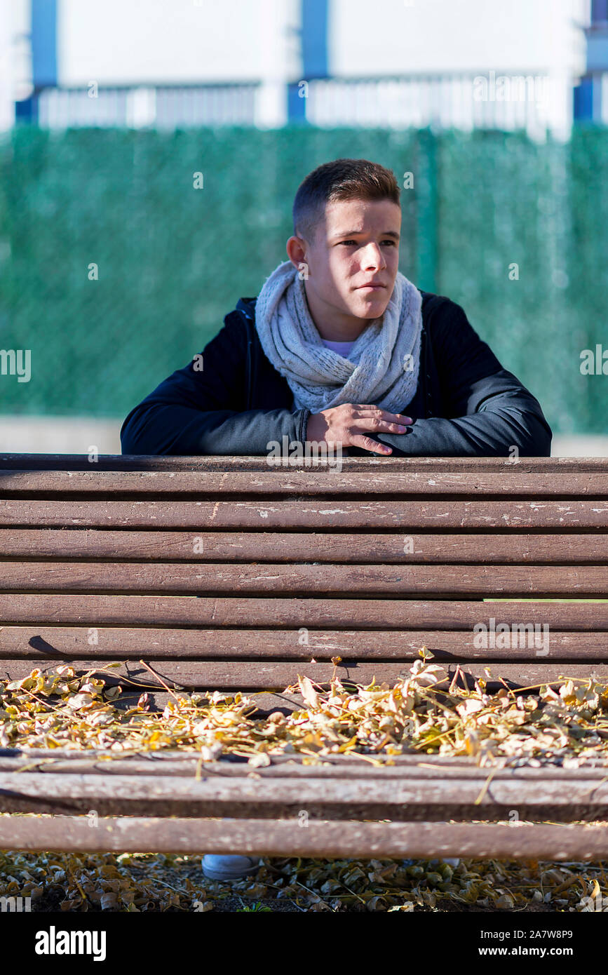 Teenager man in relax posture in garden wooden bench Stock Photo - Alamy