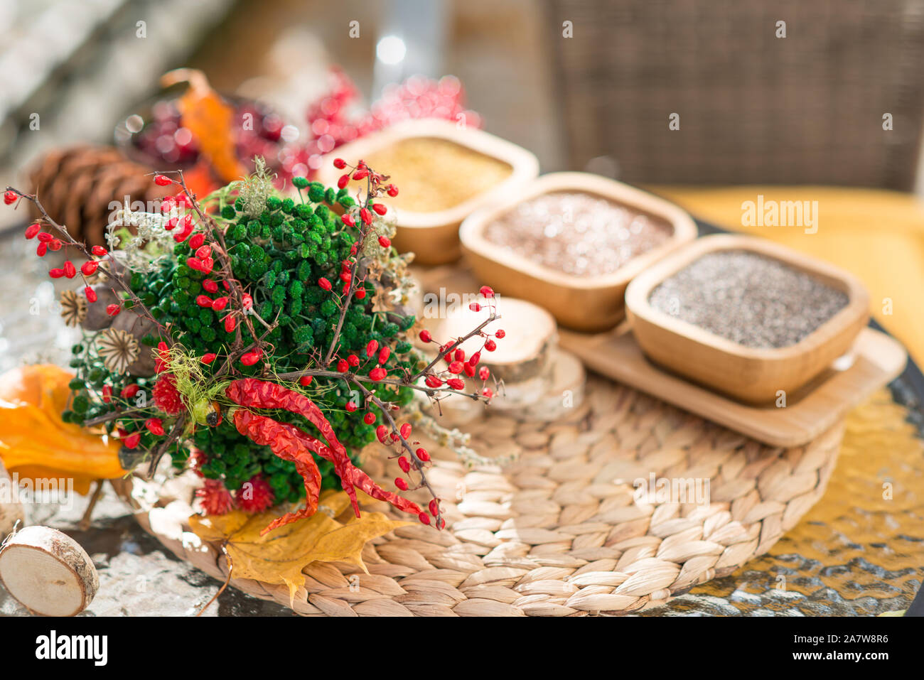 Different seeds in wooden bowls with dry natural decorations in autumn ...