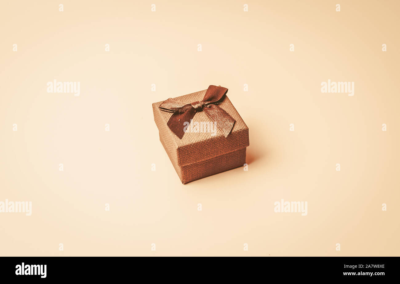 Vintage beige box with brown ribbon on a beige isolated background ...