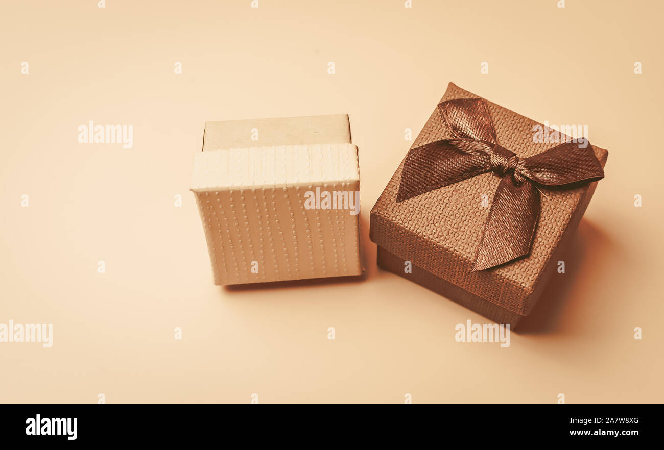 Two vintage beige boxes with a bow on a beige isolated background. Soft ...