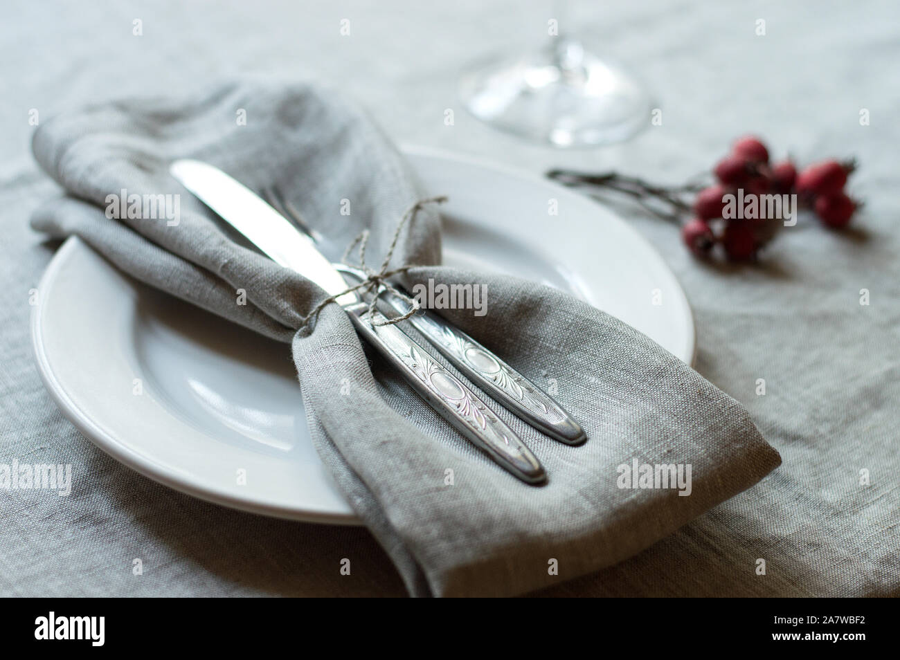 Table setting with white dinner plate rustic cutlery, linen napkin and ...