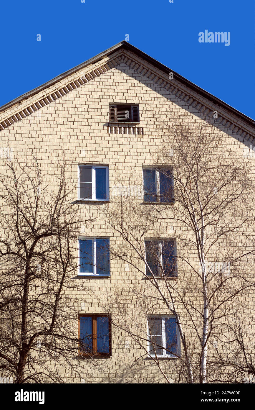 Brick house with sloping roof with six windows in the wall and two dry ...