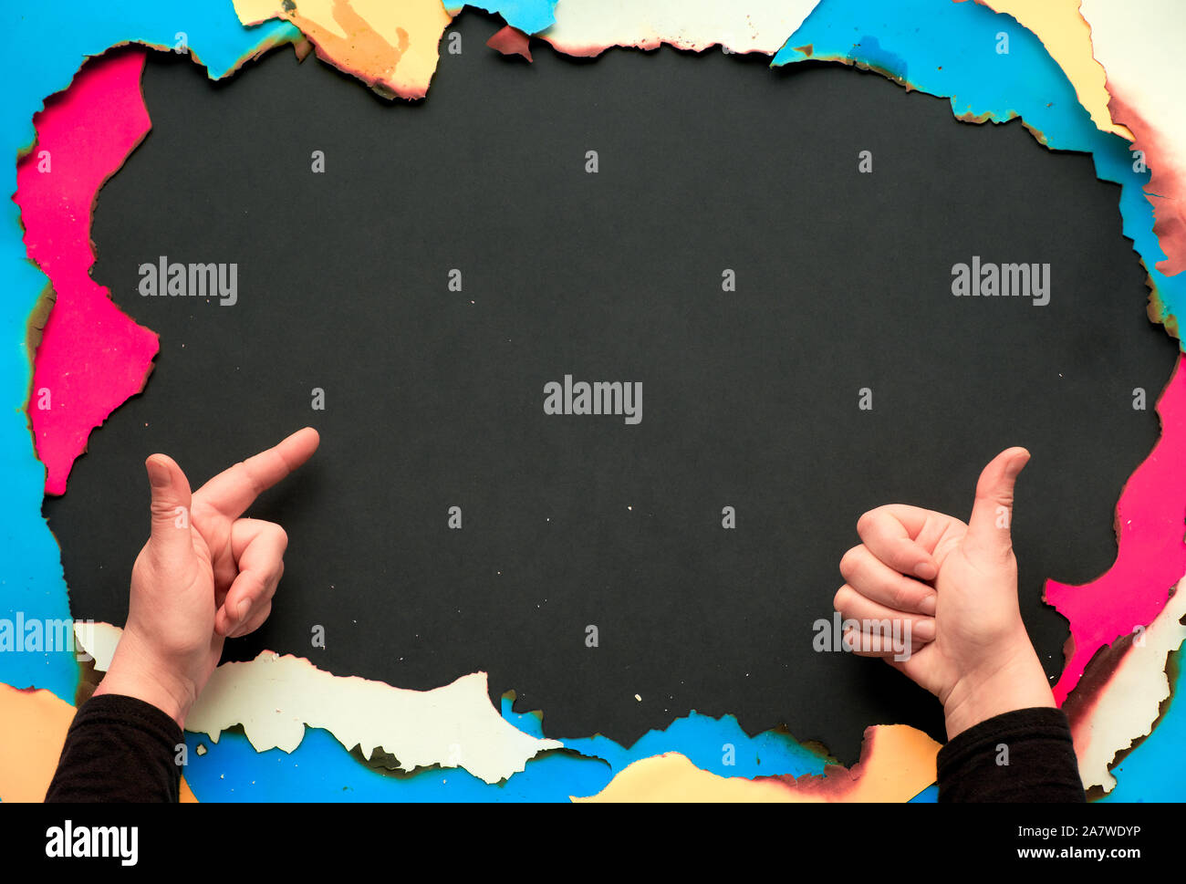 Burnt paper frame with white, red, yellow and turquoise paper with ...