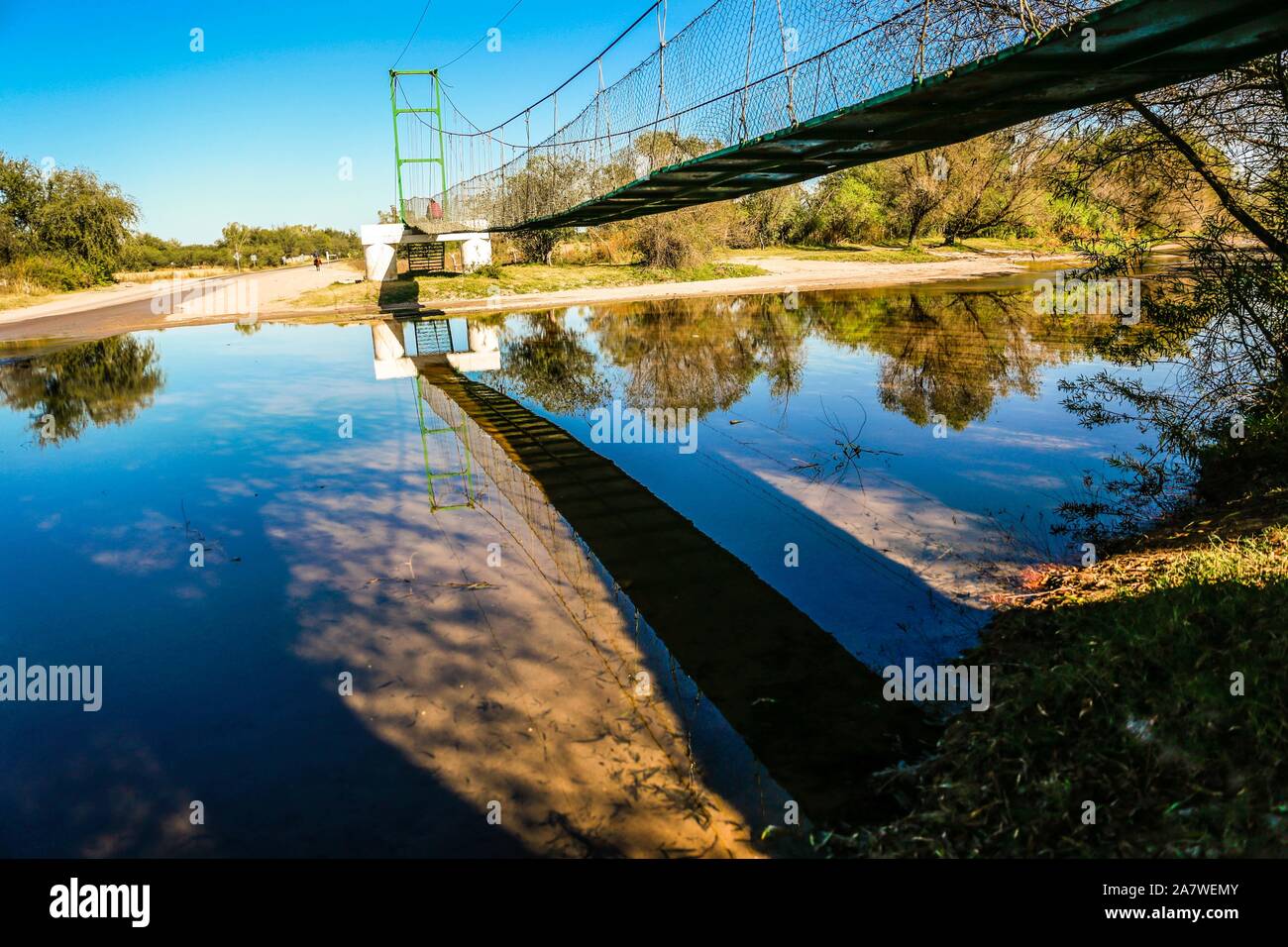Suspension bridge over the Sonora river water flow as it passes through ...