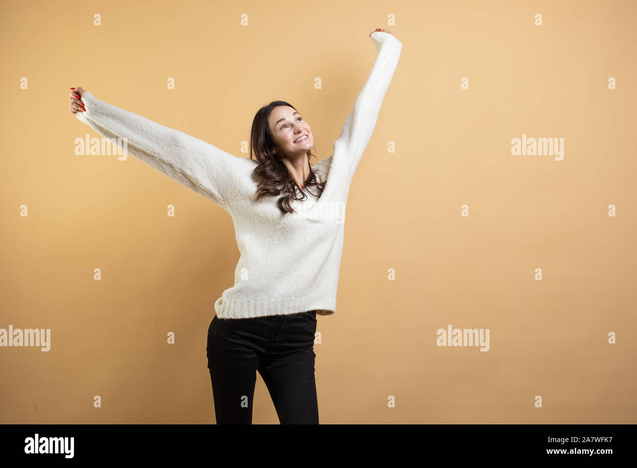 An image of a young beautiful woman in a white sweater posing on an ...
