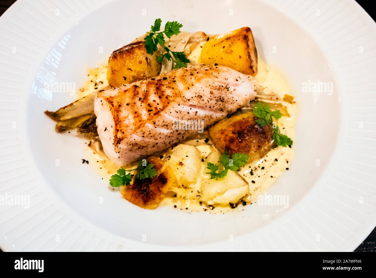 Grilled cod with new potatoes and vegetables with a cream sauce Stock ...