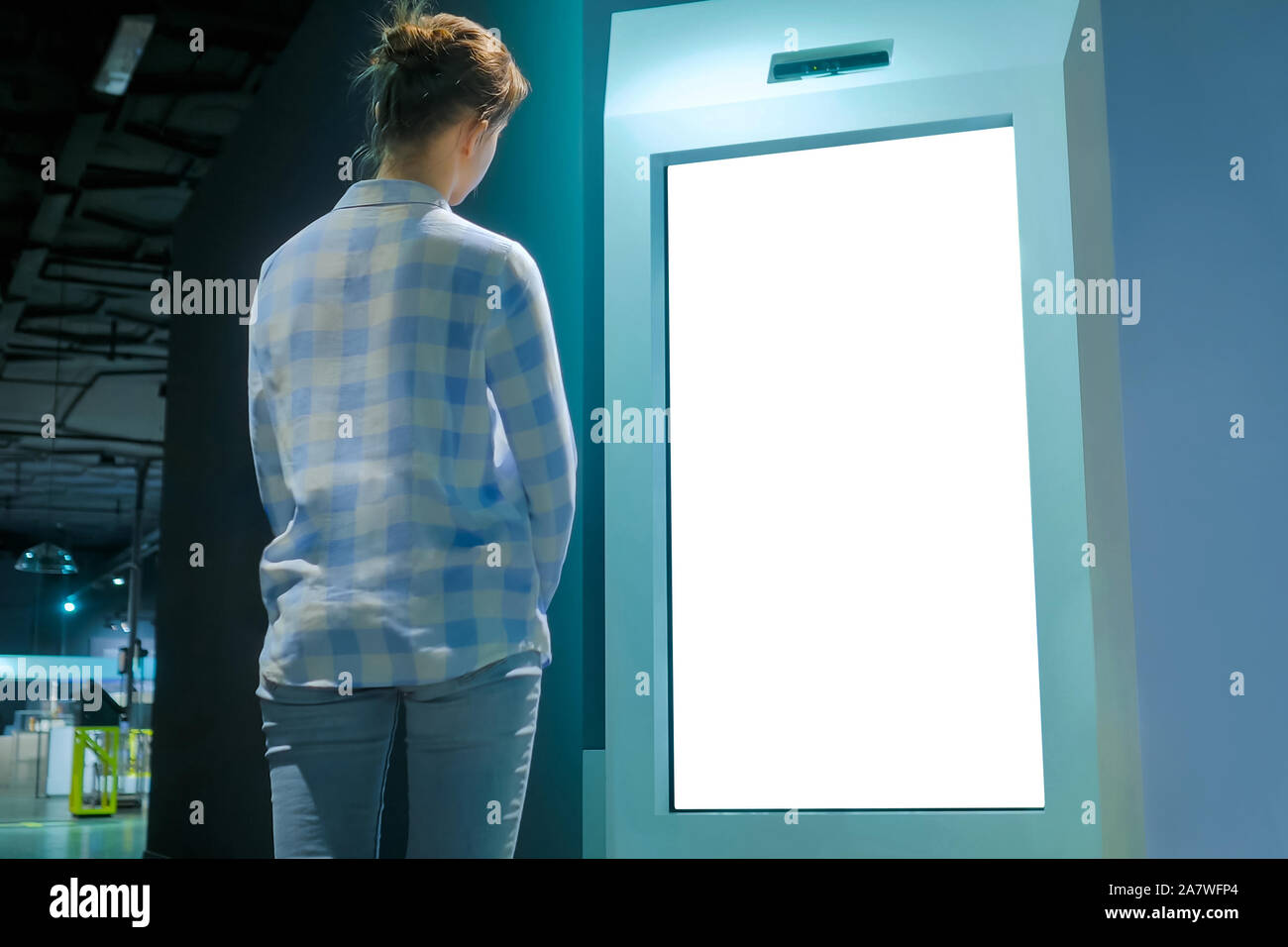 White screen concept - woman looking at blank interactive white display ...