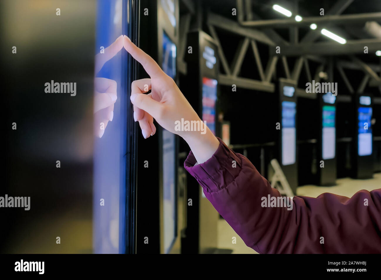 Woman hand using touchscreen display of interactive kiosk at exhibition ...