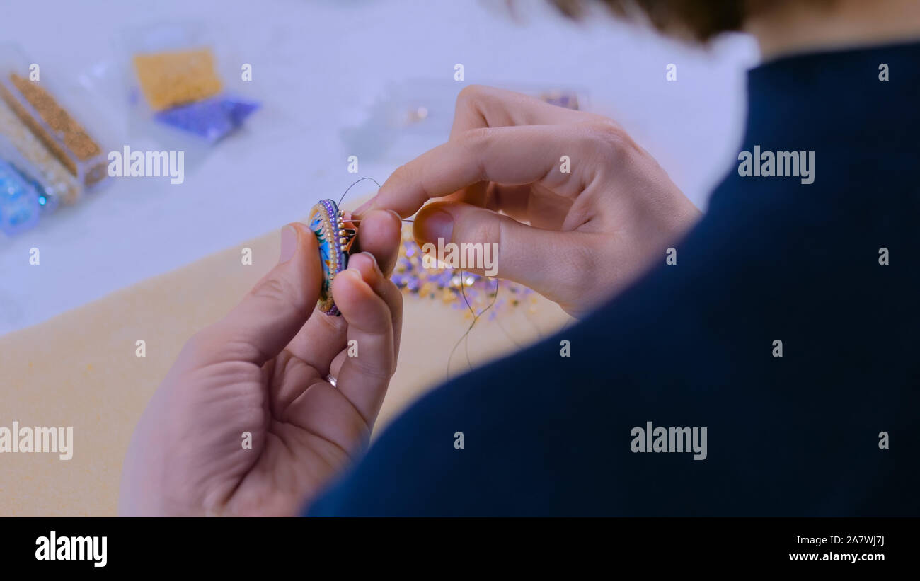 Designer making handmade brooch Stock Photo - Alamy