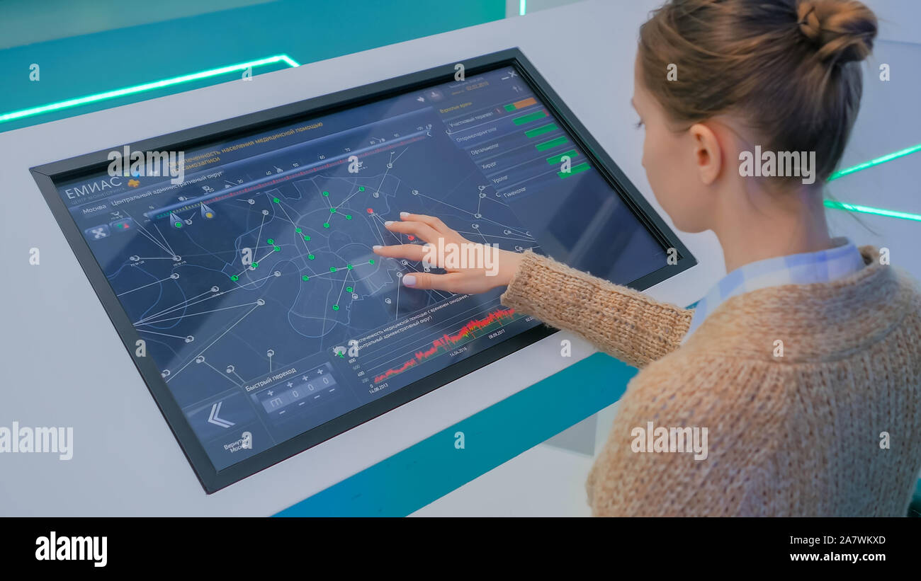 Woman using interactive touchscreen display at modern museum or ...