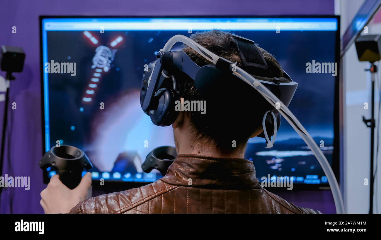 Man using virtual reality headset and playing action shooter game Stock ...