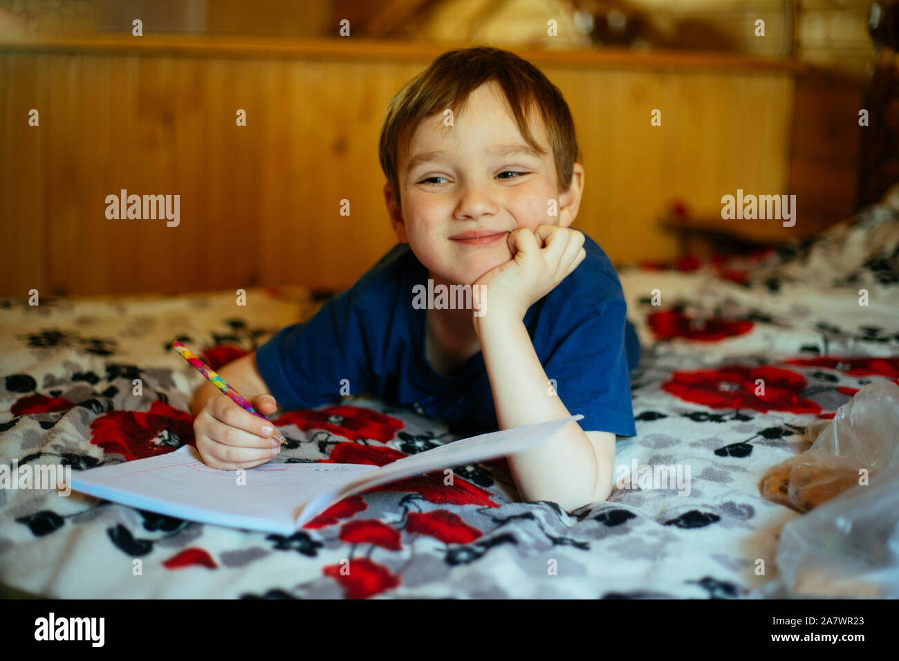 child boy doing homework lying on bed Stock Photo - Alamy