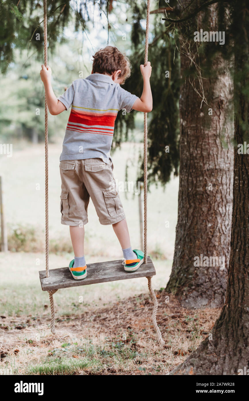Children playing on tree swing hi-res stock photography and images - Alamy