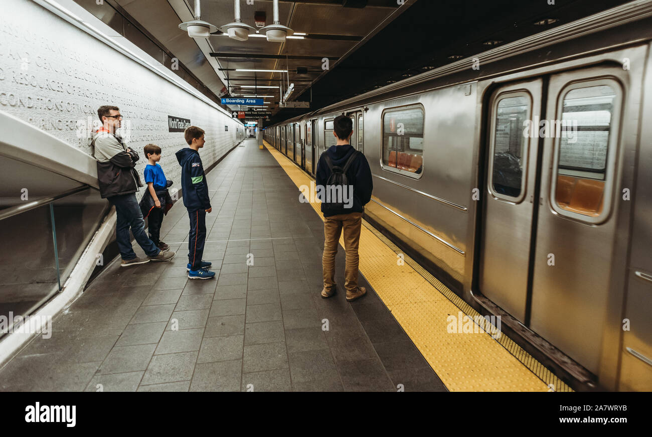 Father and three sons waiting to ride the subway in New York City Stock ...