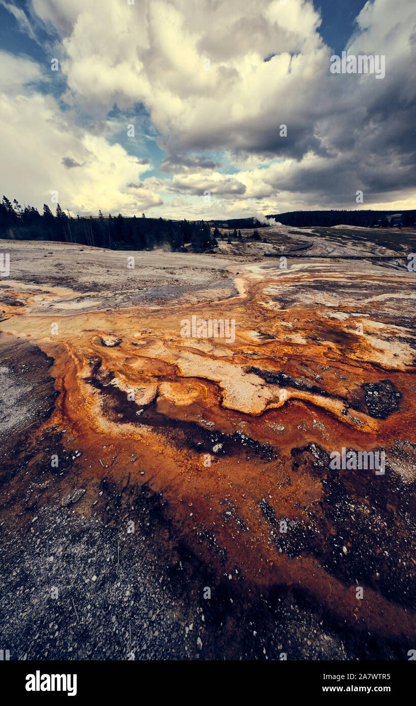Looking over a hot spring with bands of red bacteria in boiling water ...