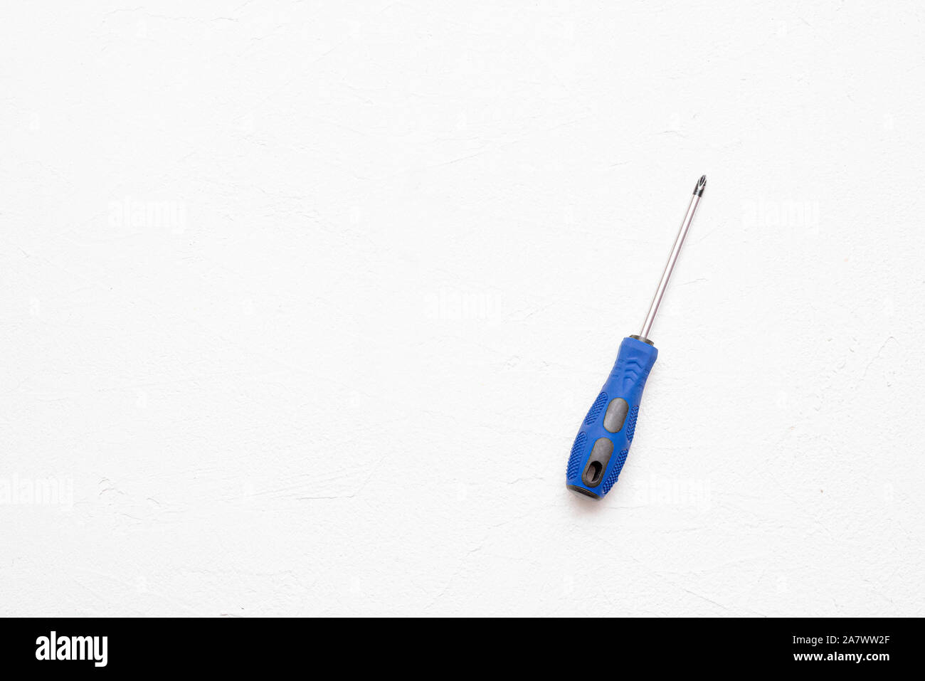 Screwdriver with blue handle on a white flat lay background with copy ...