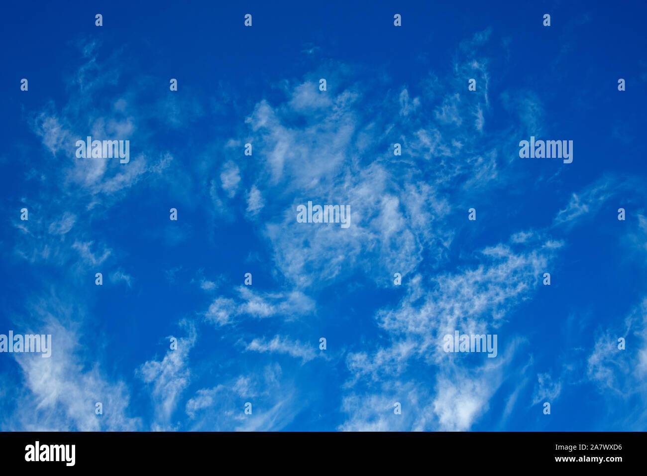 A deep blue sky with white Cirrus Fibratus, clouds floating by in rural ...