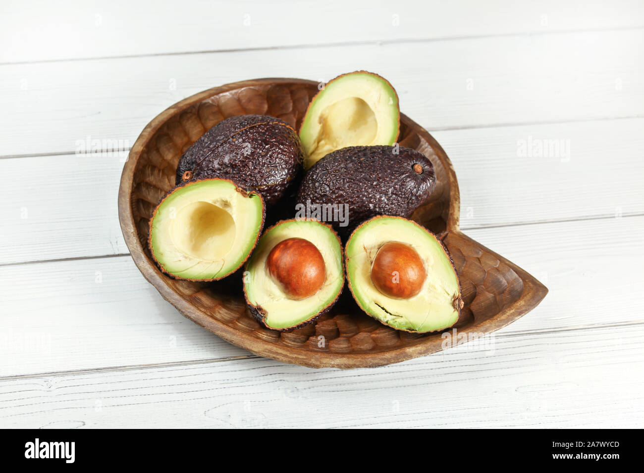 Ripe dark brown avocados - Hass Bilse variety - some cut in half, seeds ...
