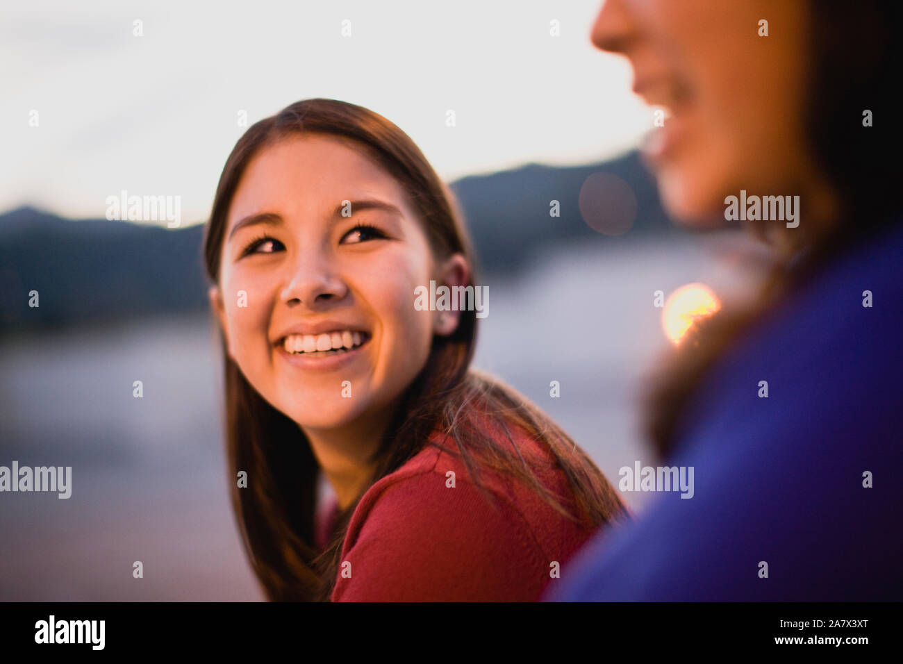 Girl smiling at friend Stock Photo - Alamy