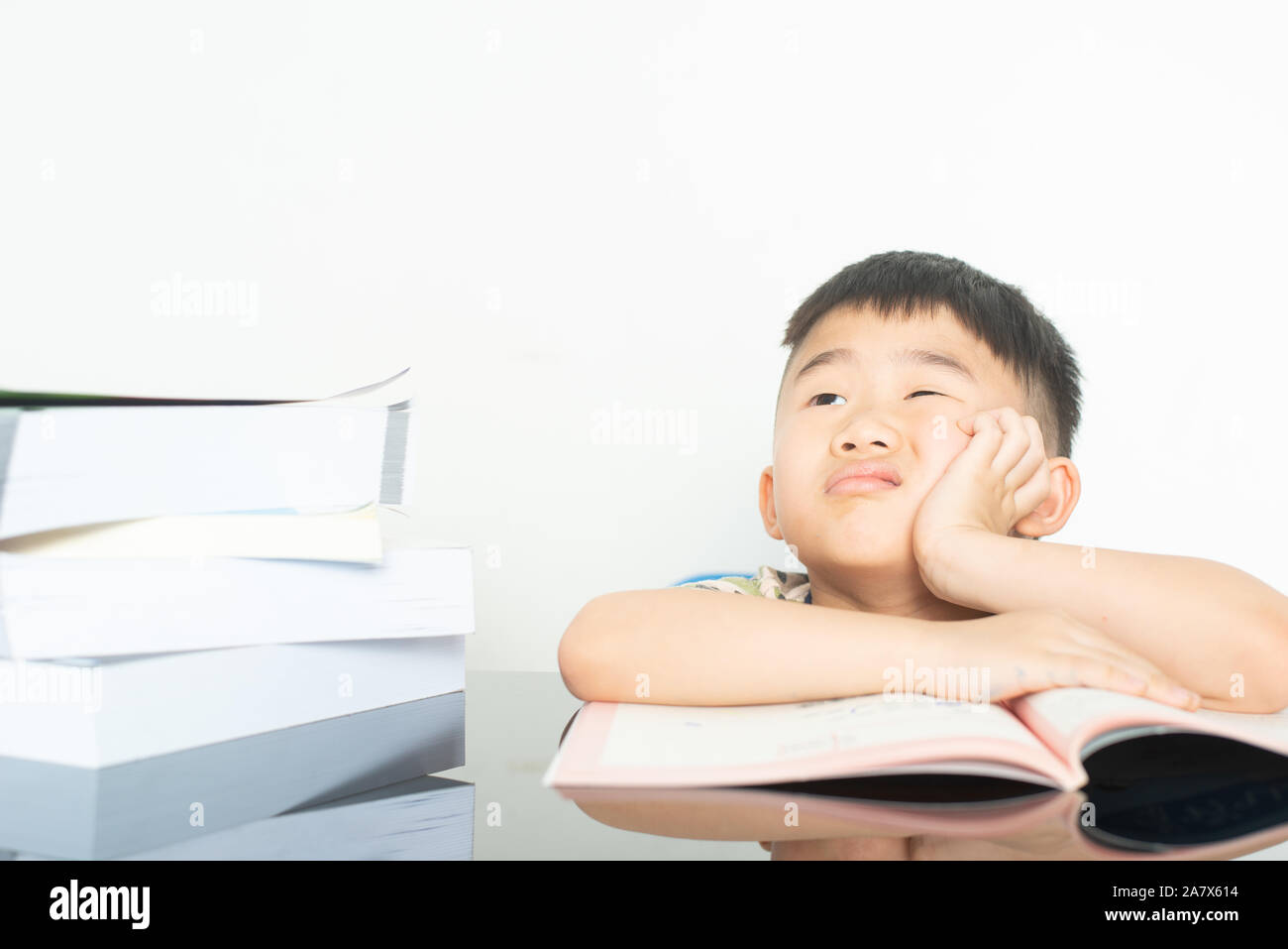 Asian cute boy are bored with reading books very much of the school ...