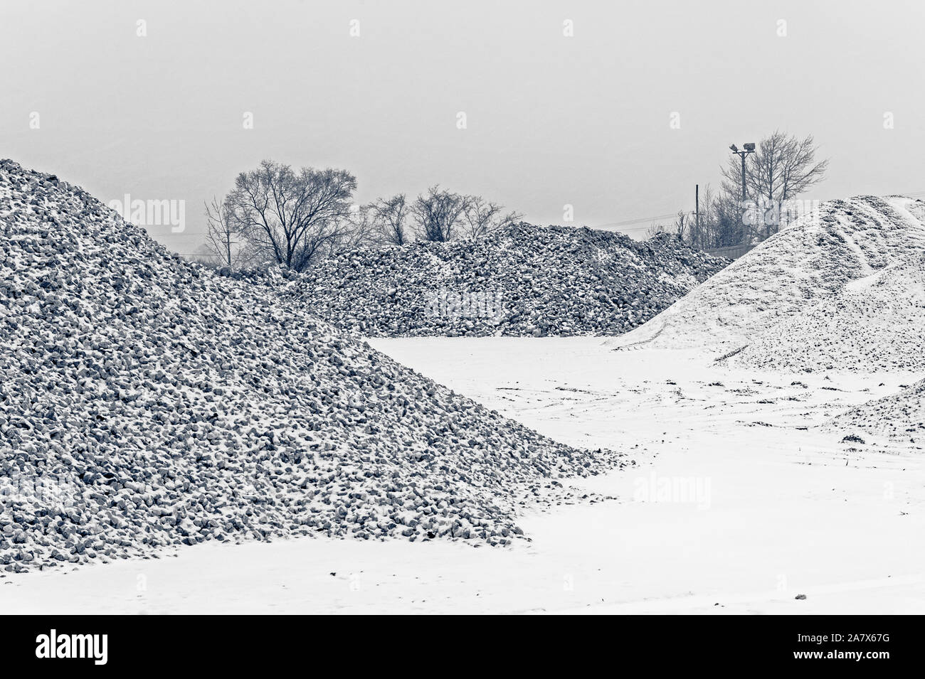Rock and stone piles at a local road construction company in the winter ...
