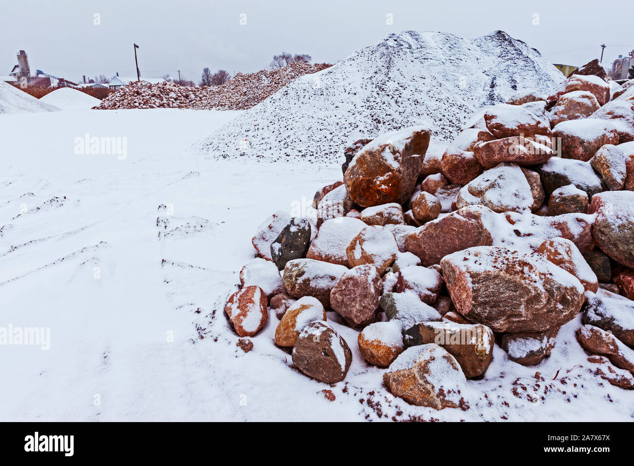 Rock and stone piles at a local road construction company in the winter ...