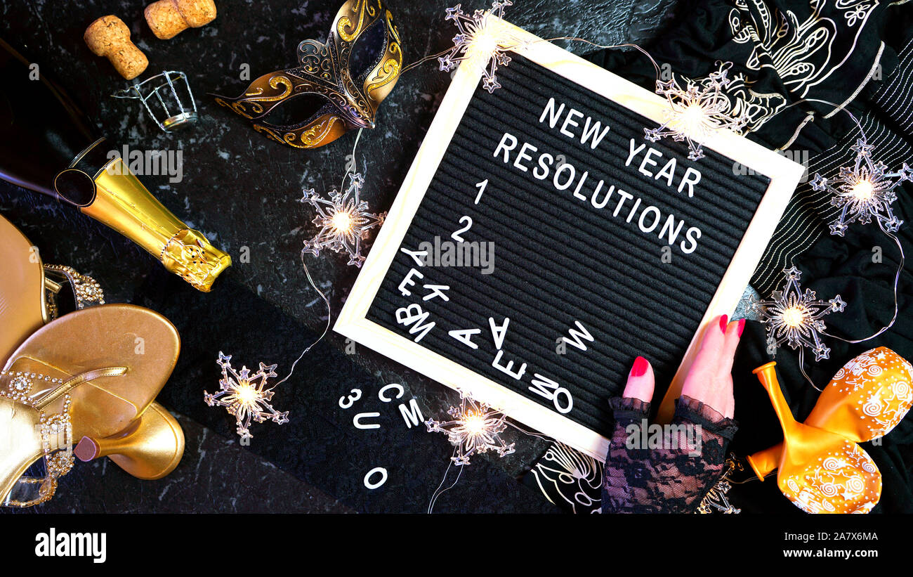 New Year's Eve resolutions flatlay with letter board and black and gold ...