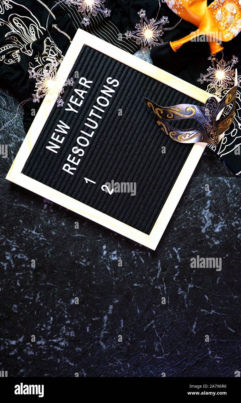 New Year's Eve resolutions flatlay with letter board and black and gold ...