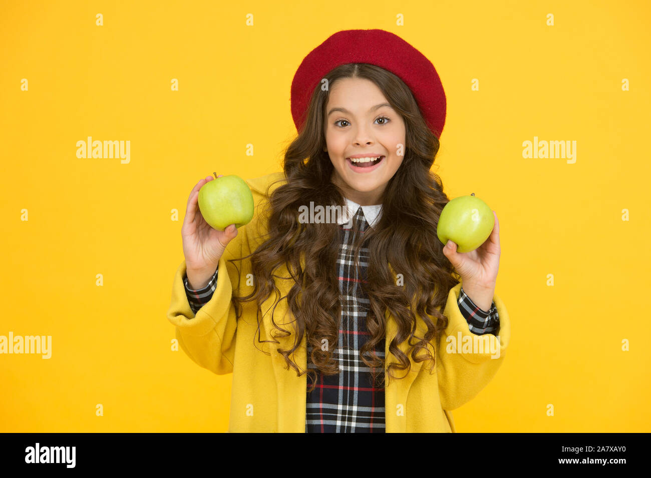 Back to school snack. Happy child hold natural apples yellow background ...