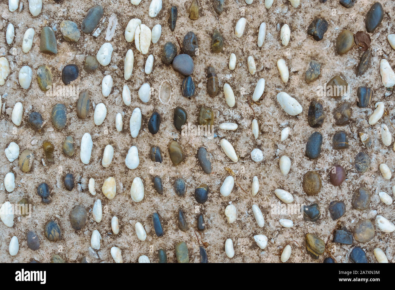 The top view of the dark and white pebbles pathway is a curved path in ...
