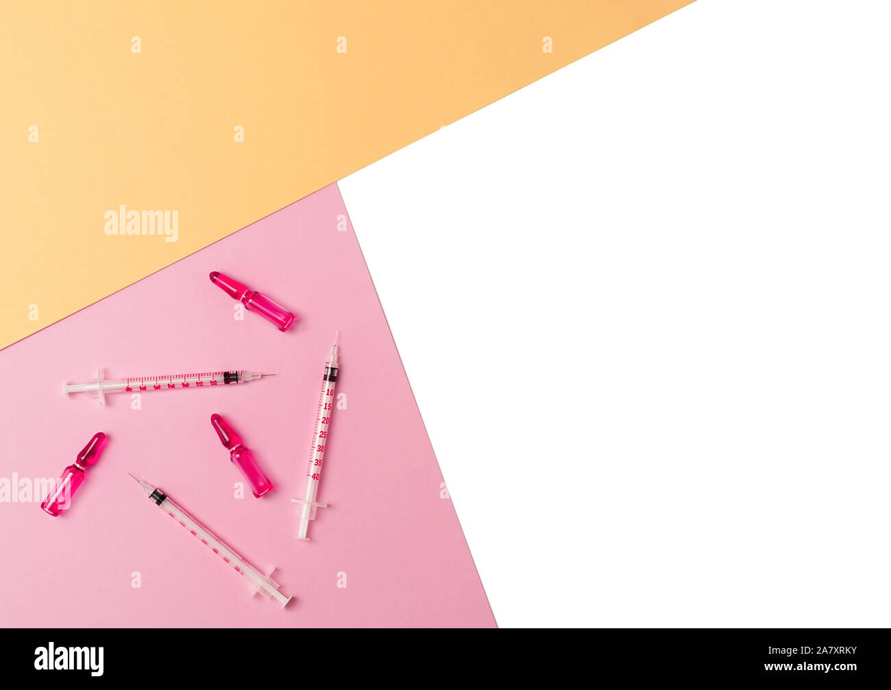 Syringes and ampules with pink liquid on isolated white, pink and ...