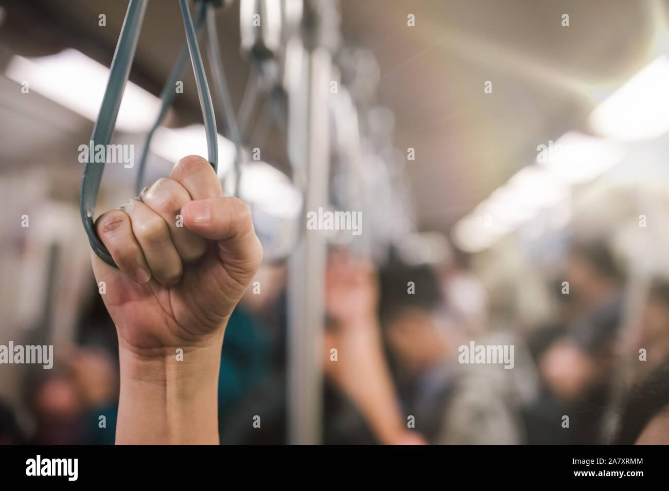 young passenger woman hand holding Handle on the train or on the bus ...
