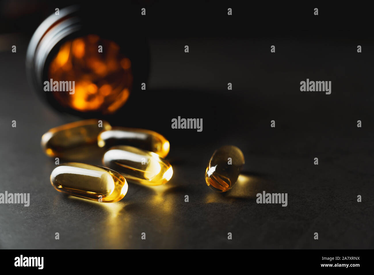 Macro photo of Omega 3 capsules and a derk glass jar on a black ...