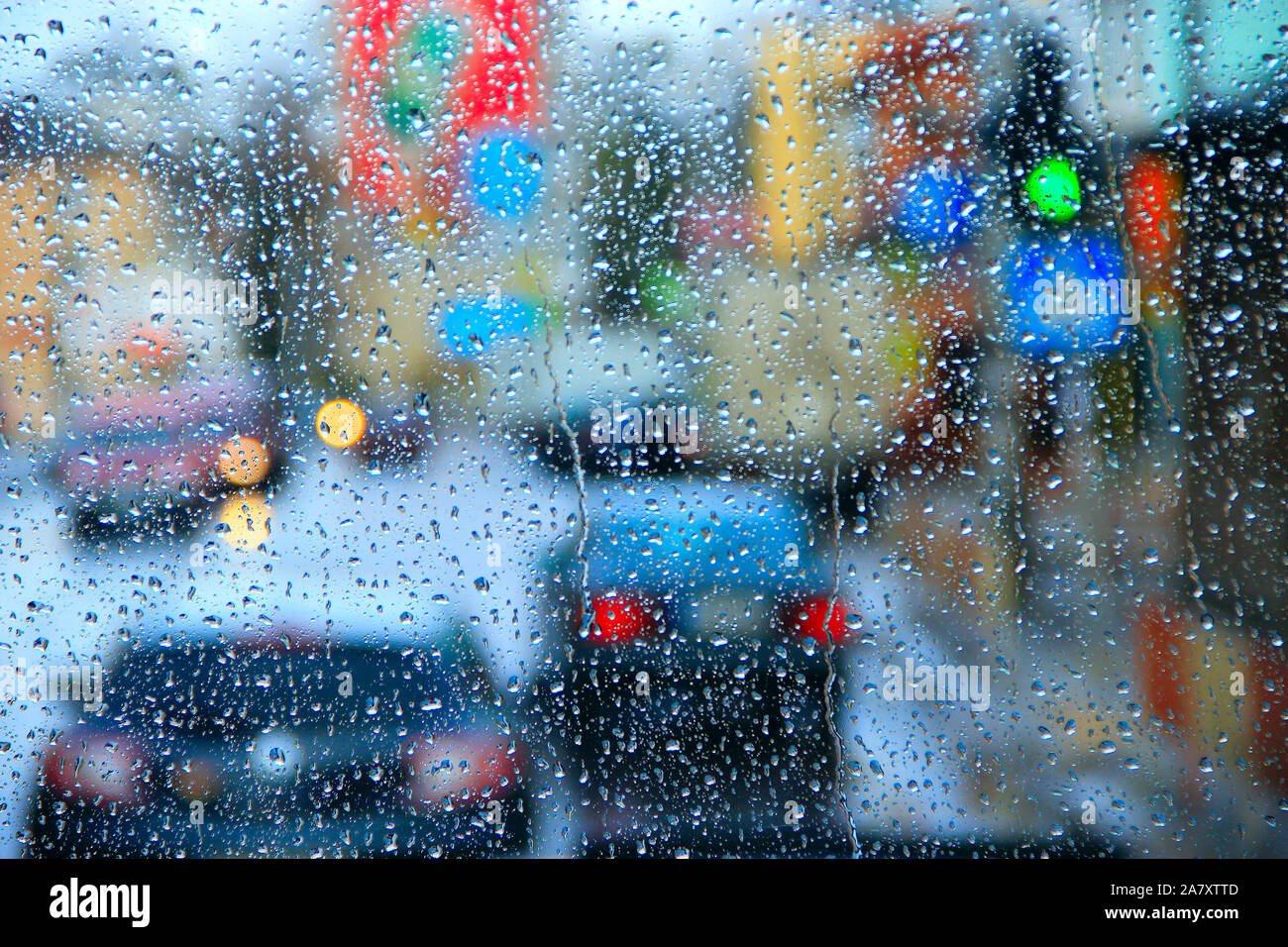 Rain outside window on background of city lights. Drops of water ...