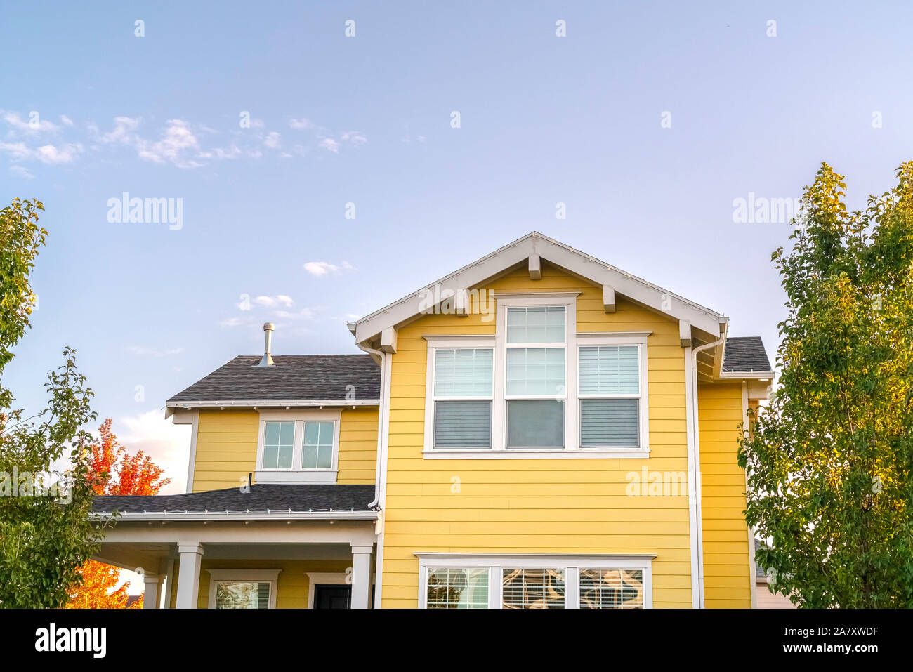 Colorful yellow double storey home in day Stock Photo - Alamy