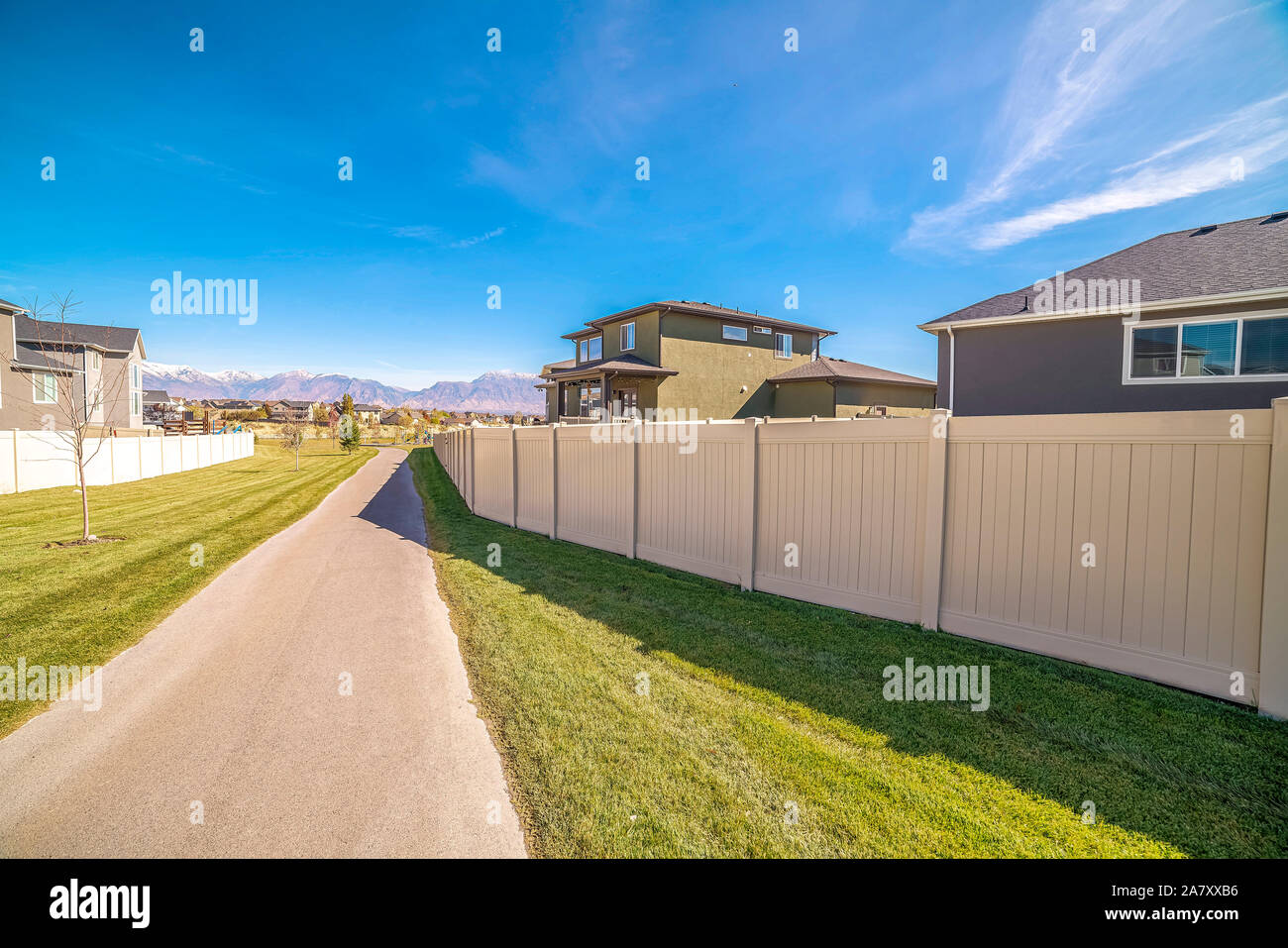 Long pedestrian walkway between walled houses during day Stock Photo ...