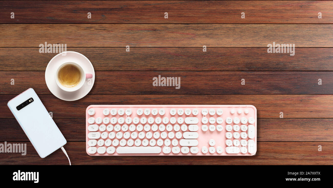 Female office desk. Computer keyboard pink color and mobile phone ...