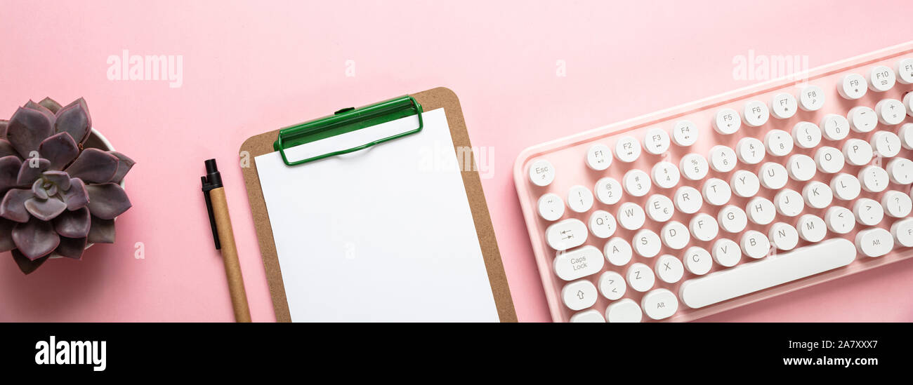 Woman office desk. Computer keyboard and notepad against pink ...