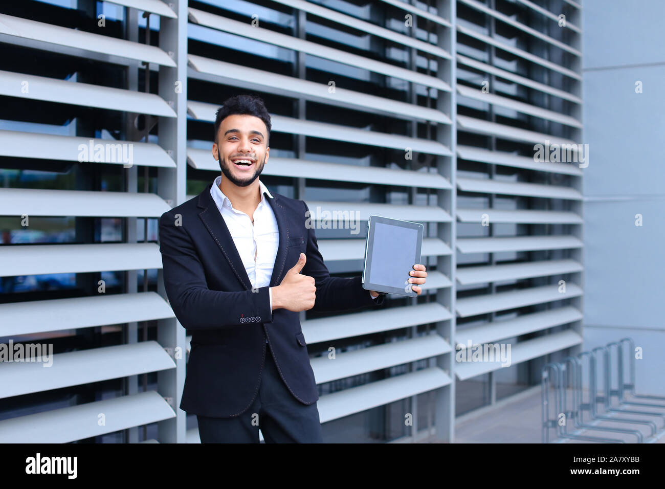 Arabic guy in business center stands smiling Stock Photo - Alamy