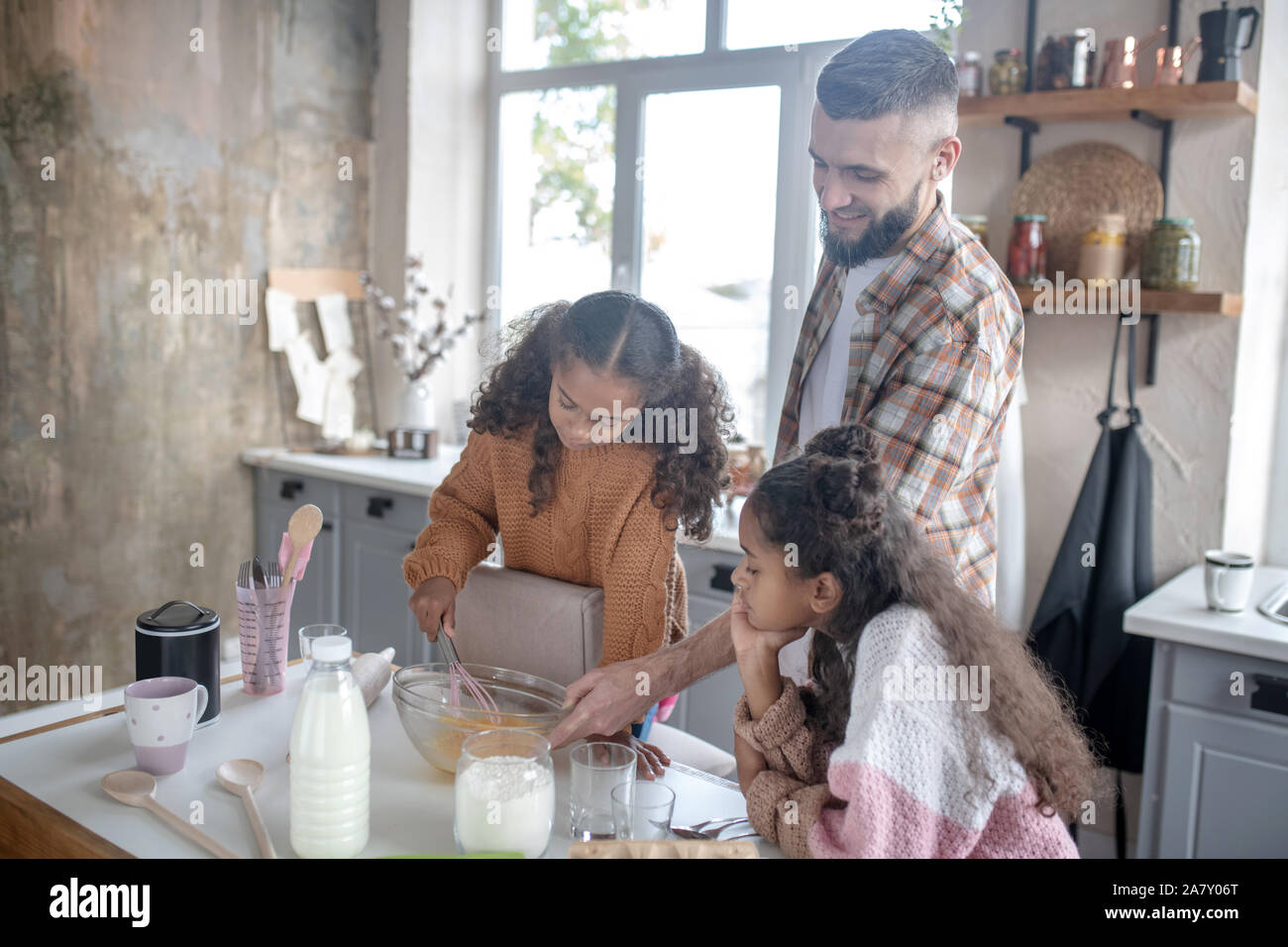 Curly cute girls feeling involved in cooking with daddy Stock Photo - Alamy