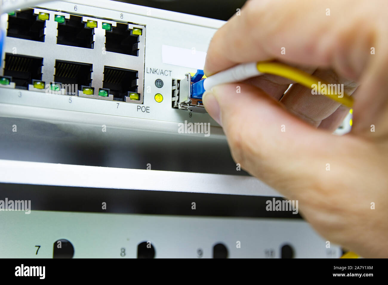 Technician connect fiber cable network to switch port in server room ...